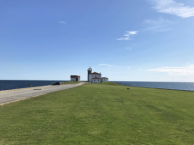 Watch Hill Lighthouse stands sentinel at land's end, a whitewashed guardian that's witnessed more dramatic ocean moods than a maritime therapist.