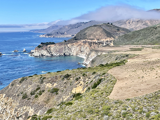 The coastal highway curves like nature's signature on California's most impressive canvas, each bend revealing another frame-worthy vista.