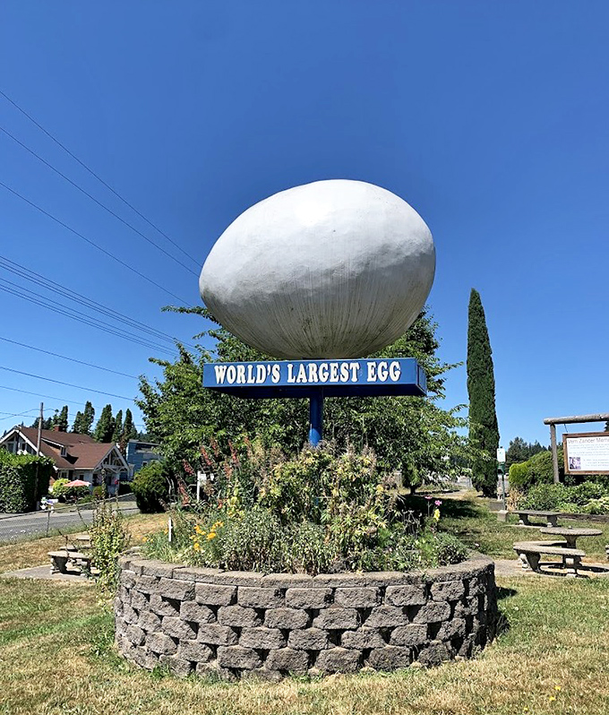 Under brilliant blue skies, the World's Largest Egg shines in all its glory, surrounded by a circular garden that frames this peculiar point of pride.