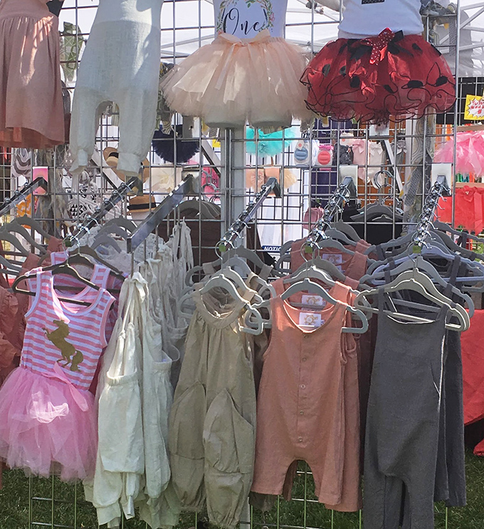 Tiny tutus and miniature rompers hanging like colorful promises of future market adventures with the next generation of food enthusiasts.