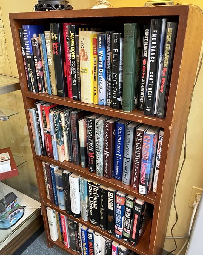 Literary time capsules line these shelves, offering everything from spy thrillers to forgotten bestsellers that once captivated readers before Netflix existed.
