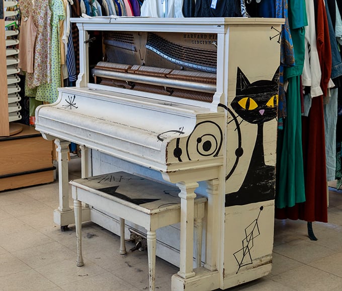 A whimsical white piano adorned with playful cat art&mdash;because sometimes your secondhand find needs to make both musical and visual statements.