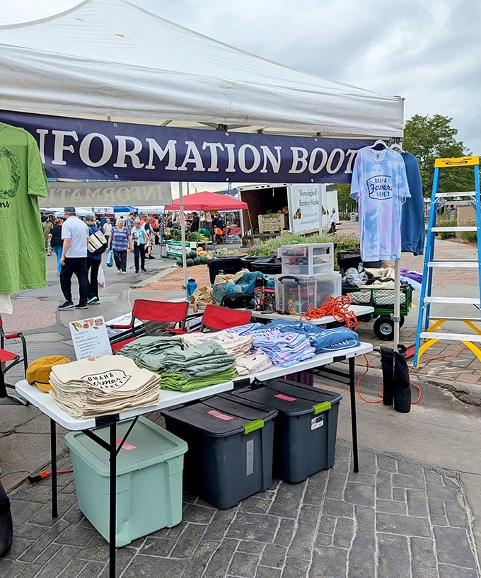 The information booth serves as market mission control, where newcomers get oriented and veterans check what's fresh this week.