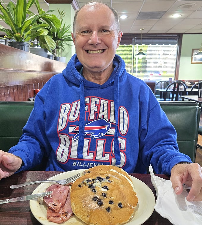 A happy diner with blueberry pancakes and ham. That smile says everything you need to know about Dianna's breakfast game.