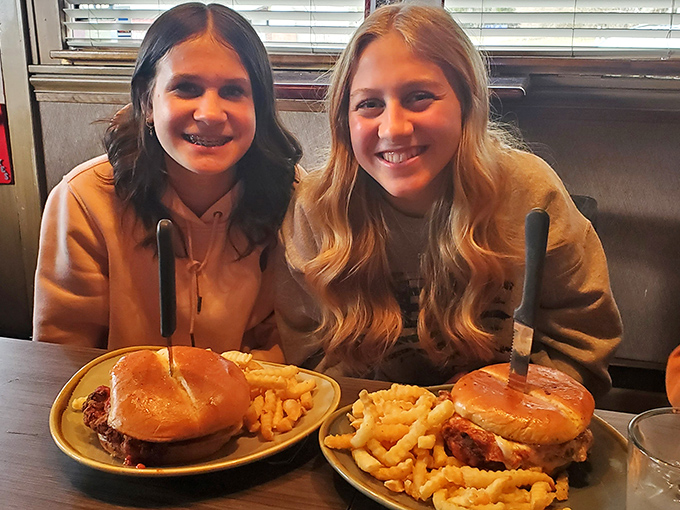 Two friends proving that happiness really is a perfectly cooked burger and a side of crispy fries.