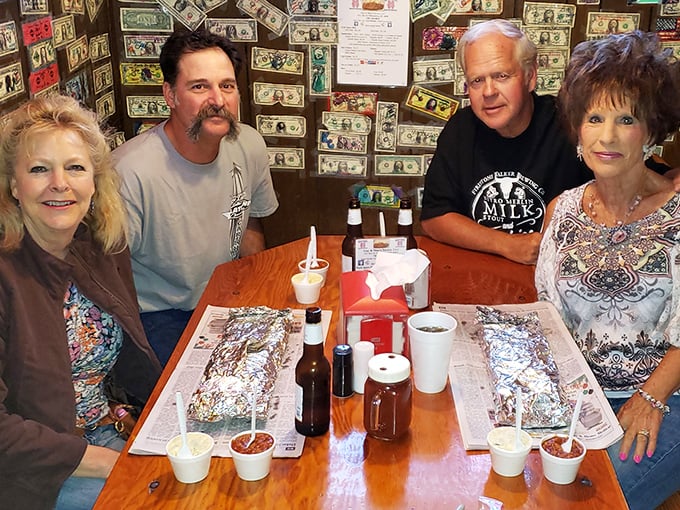 The true measure of a legendary BBQ joint: happy diners surrounded by dollar bills, with sauce-stained napkins as badges of honor.