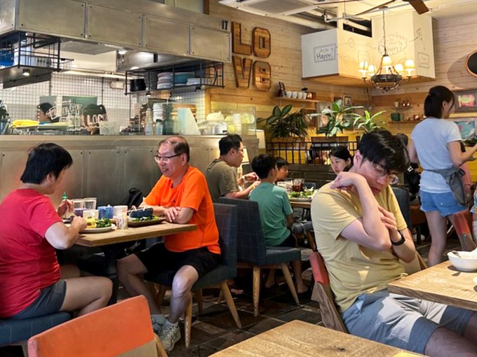 A dining room where strangers become temporary neighbors, united by the universal language of "that looks amazing, what did you order?"