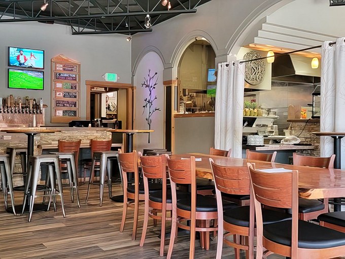 The dining room balances rustic charm with modern comfort. Those arched doorways and wooden tables create the perfect backdrop for serious pizza consumption.