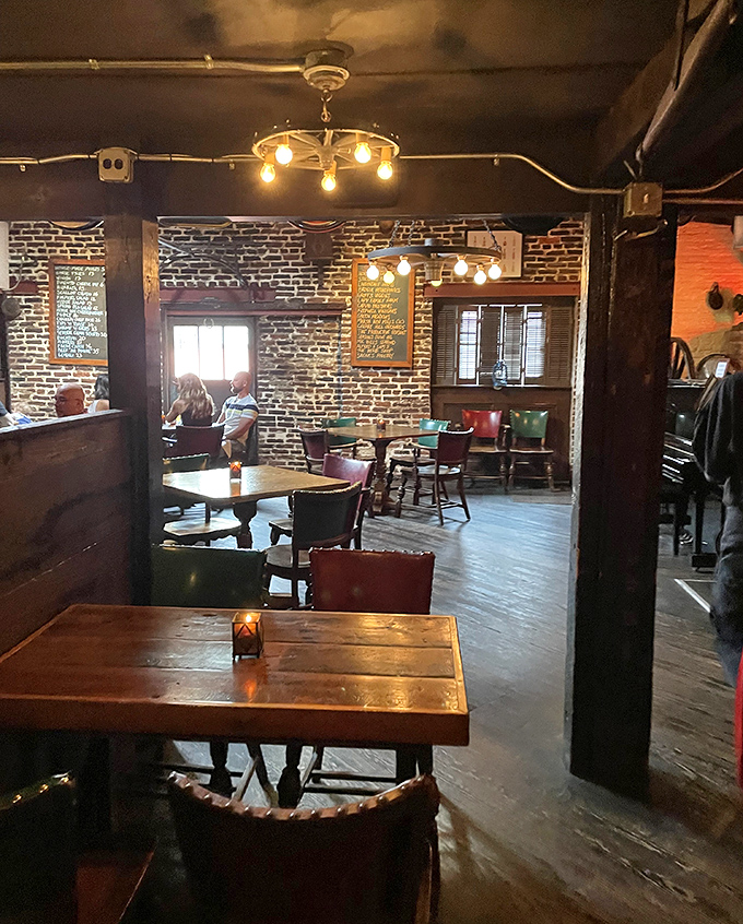 Wooden tables bathed in amber light create dining nooks where conversations flow as smoothly as the cocktails. Edison would approve.