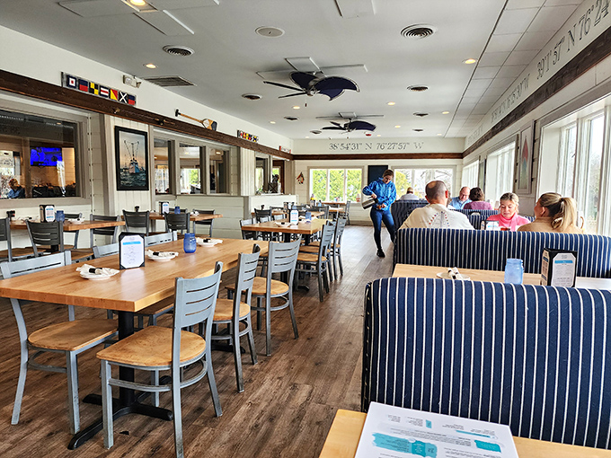 The dining room balances casual comfort with waterfront charm. Those blue-striped booths aren't just seating&mdash;they're front-row tickets to a Maryland seafood symphony.