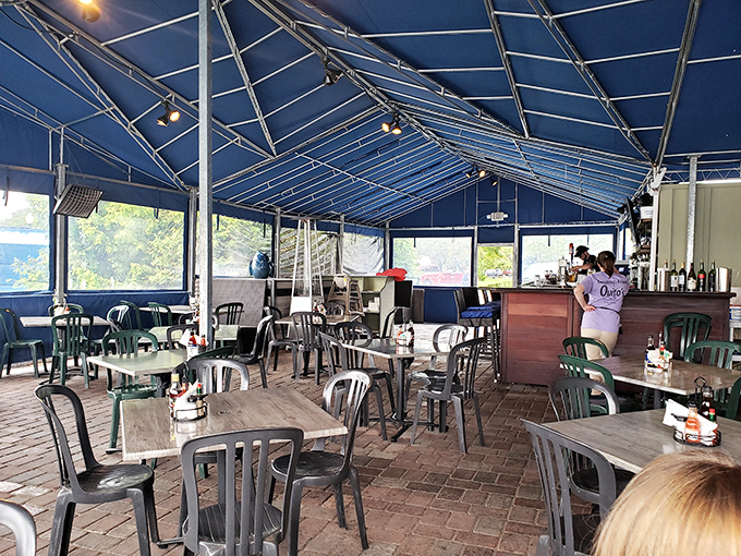 Under the blue canopy, casual tables await diners ready to embrace waterfront dining at its most relaxed.