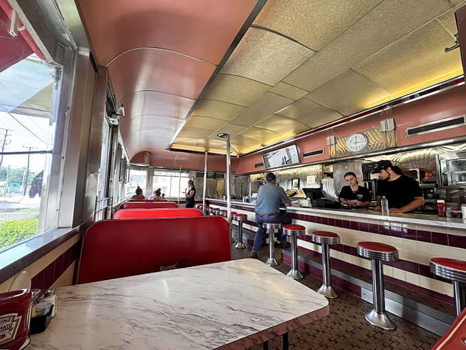 Classic diner geometry: red booths, marble tables, and conversations that bounce off the ceiling like the morning light.