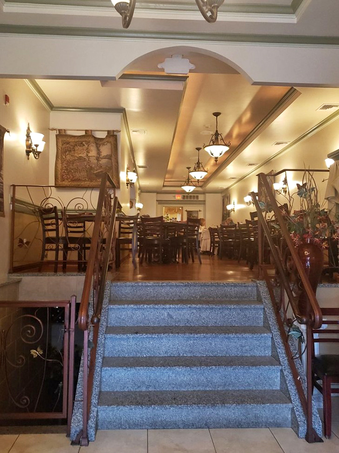 The elegant staircase and warm lighting create an atmosphere where you feel like you're dining in someone's particularly stylish Italian home.