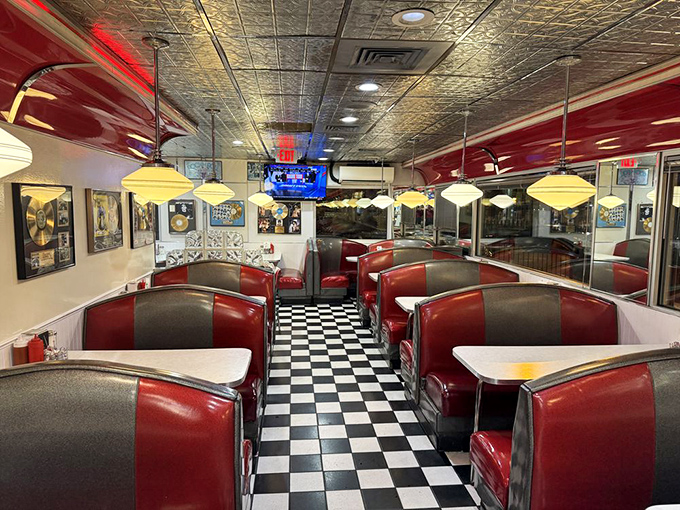 The dining area stretches before you like a red vinyl sea, each booth an island of potential breakfast bliss under pressed tin ceilings.