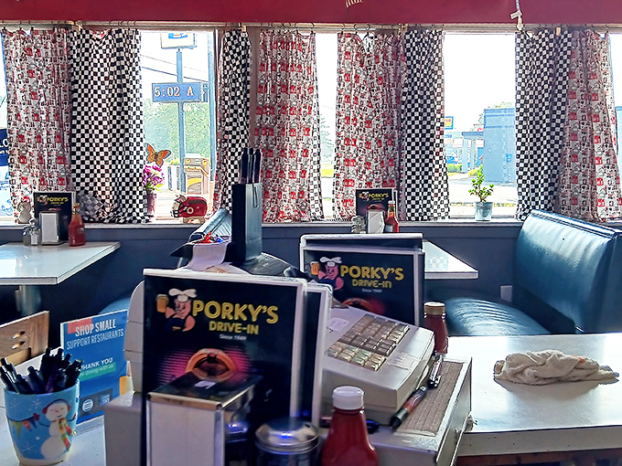 The checkered curtains and blue booths aren't retro by design&mdash;they're authentic by survival, creating the perfect backdrop for memorable meals.