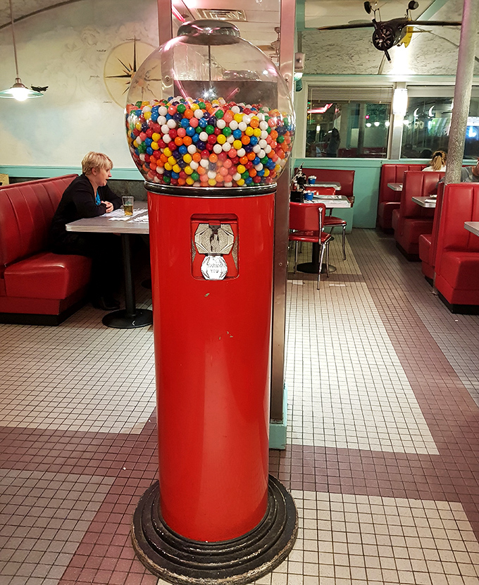 The vintage gumball machine stands sentinel among the booths, a colorful reminder that sometimes life's simplest pleasures are the sweetest.