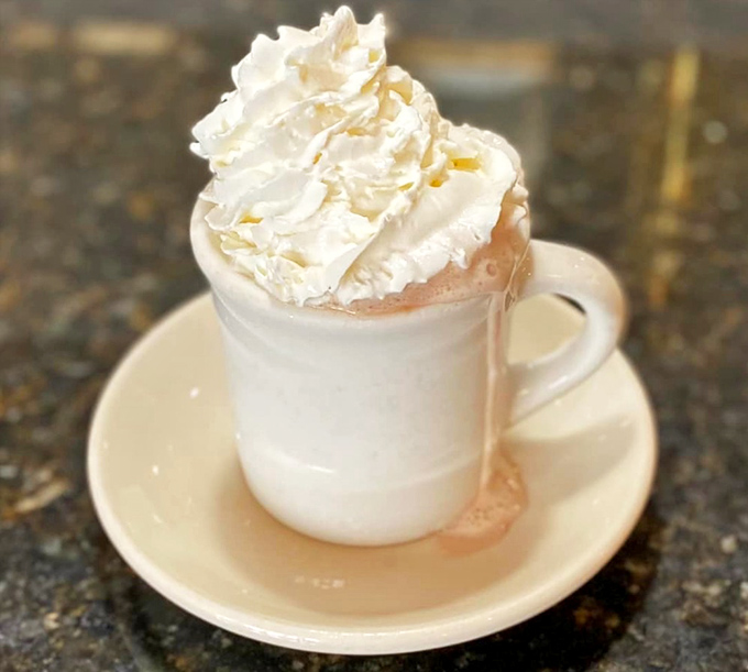 Hot chocolate that's dressed for a special occasion, topped with a whipped cream hat that's practically begging for a selfie.