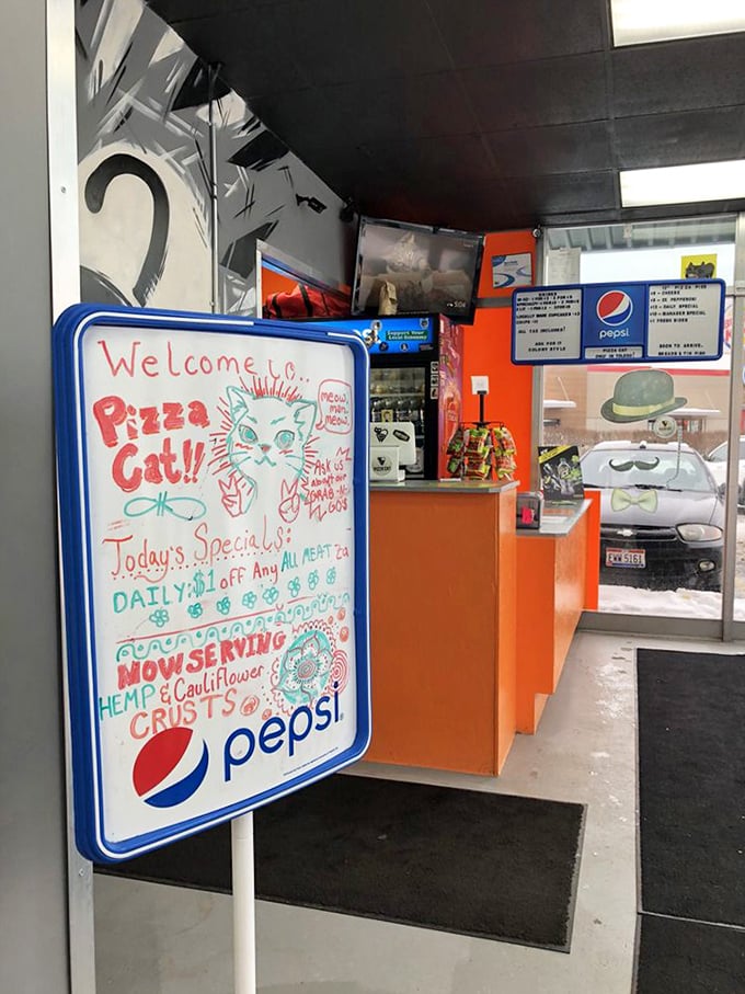A handwritten welcome board announces daily specials and alternative crusts, proving Pizza Cat embraces both tradition and dietary innovation.
