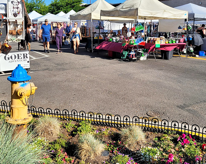 Even fire hydrants get dressed up for market day, standing guard beside carefully tended flowers as shoppers browse nearby.
