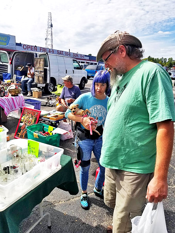 Shoppers examining glassware with the careful scrutiny of archaeologists&mdash;complete with tiny dog assistant.