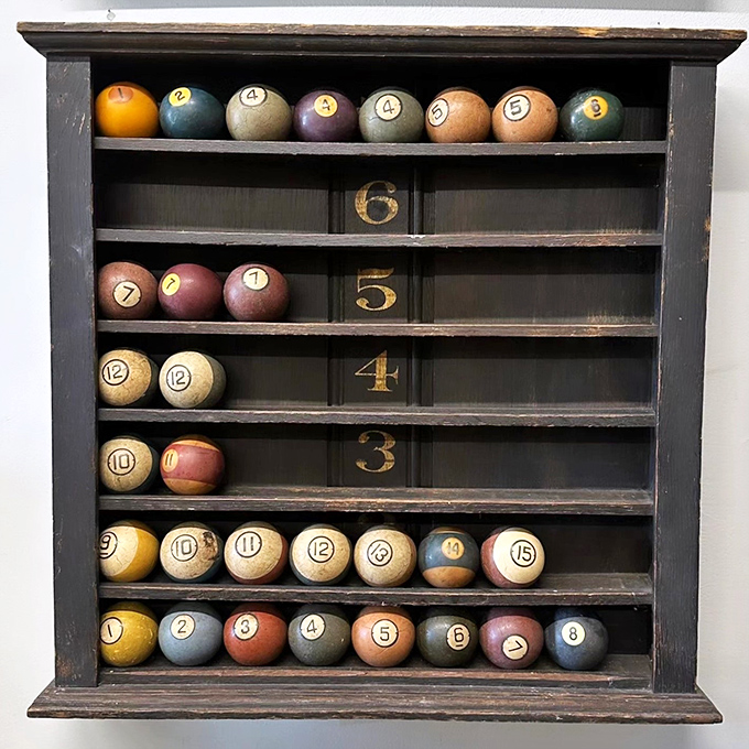 This billiard ball display case transforms game pieces into mathematical art. Each numbered sphere waits patiently for a game that will never come.