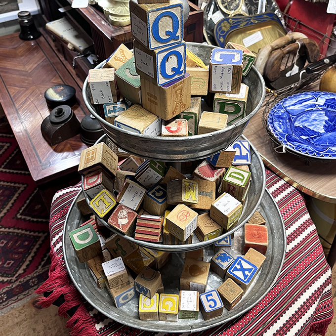 Wooden alphabet blocks in a tiered display, each one a tiny time capsule from when toys were simpler and imaginations ran wild.