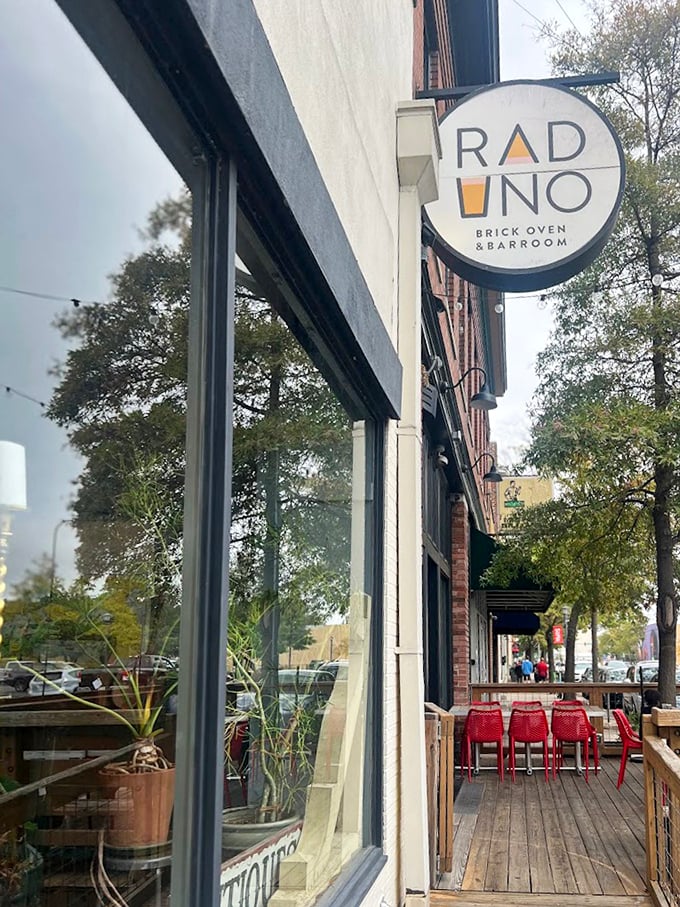 Raduno's simple circular sign hangs like a pizza promise, with red chairs waiting for those wise enough to stop.