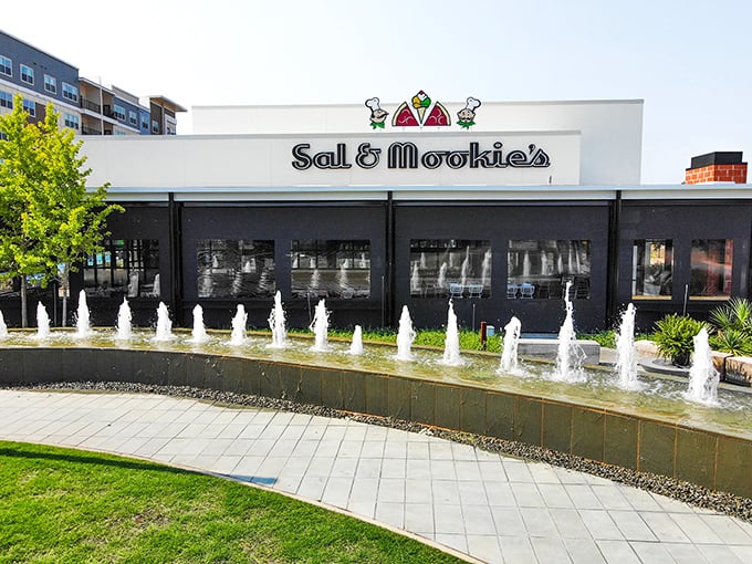 Sal & Mookie's modern exterior sits beside dancing fountains. Pizza with a side of water ballet!