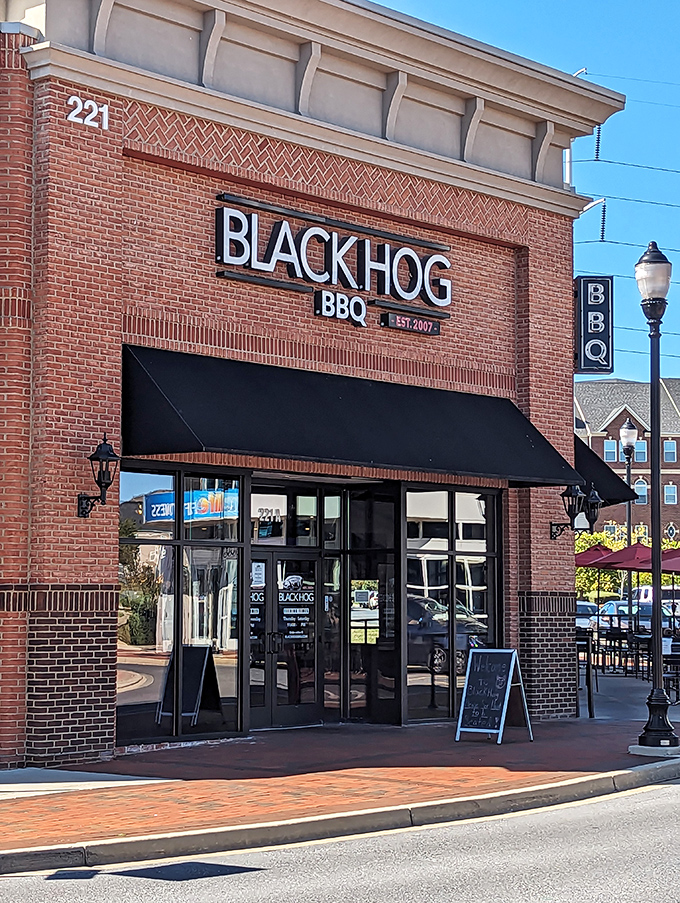Sunlight plays across Black Hog BBQ's classic storefront. That sidewalk has carried thousands of hungry folks toward smoky salvation.