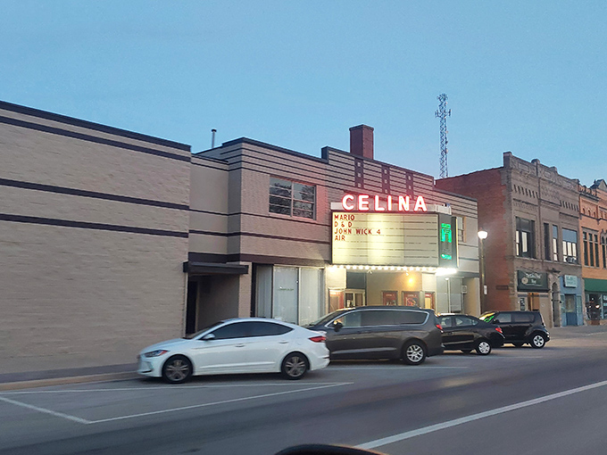 Classic theater marquee lights up downtown evenings where entertainment costs less than popcorn elsewhere.