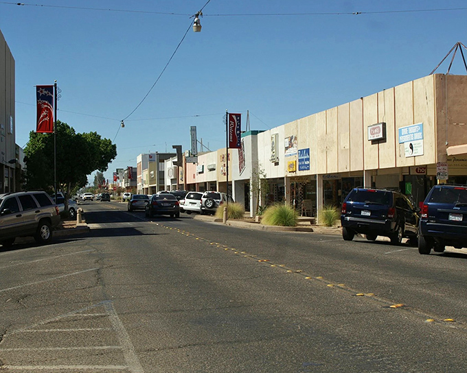 Downtown El Centro showcases its modest commercial district with local businesses lining the sun-drenched street under clear blue skies.