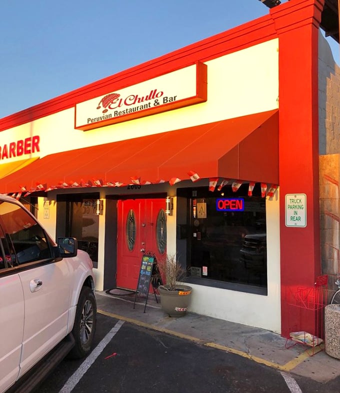 Simple exterior, extraordinary flavors at El Chullo Peruvian Restaurant. The red awning and "NOW OPEN" sign invite you to discover Lima's seafood secrets in Phoenix.