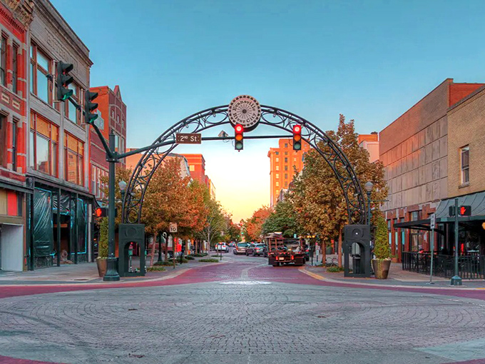 The sunset casts a golden glow on Evansville's iconic downtown arch, marking the entrance to a revitalized main street.