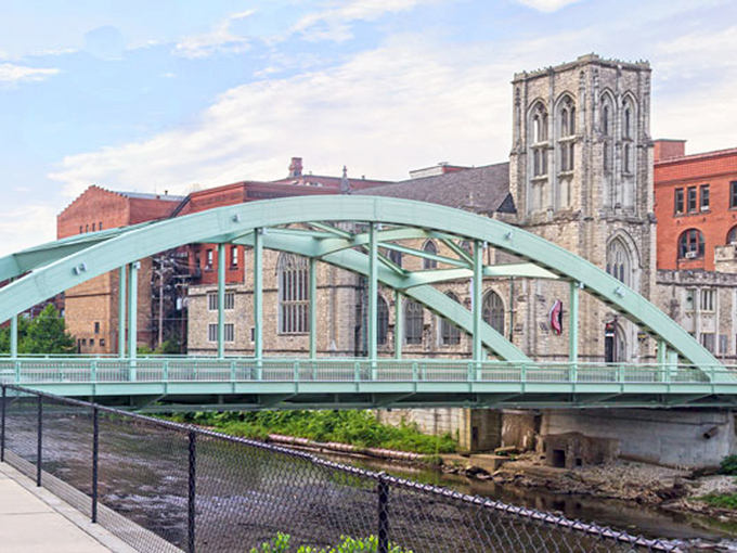 The graceful arch of Oil City's bridge spans the river, connecting neighborhoods where retirement savings stretch like the water below.