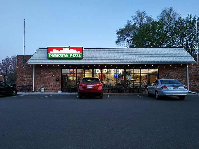 Evening at Parkway Pizza&mdash;where the glowing "OPEN" sign welcomes hungry diners to pizza comfort at its finest.
