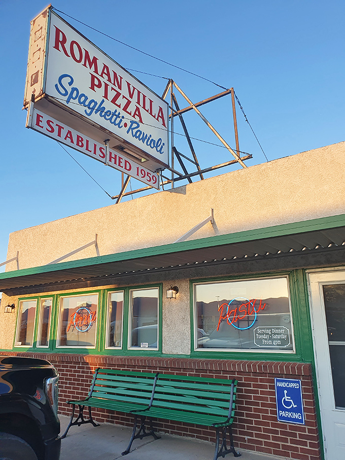 The nostalgic charm of Roman Villa's exterior, complete with that green bench, whispers of decades of pizza perfection. History you can taste.