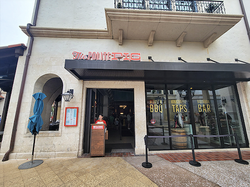 The stucco exterior and bold red signage of The Polite Pig beckons like a barbecue beacon amid Disney Springs' tourist attractions.