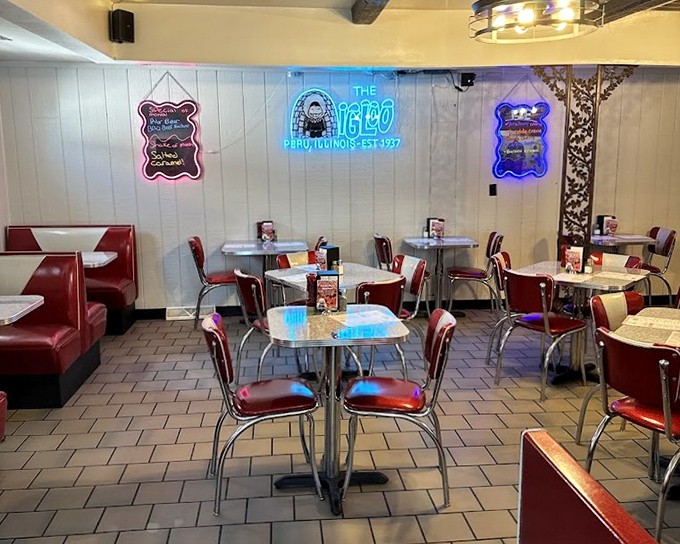 Classic diner aesthetics: red vinyl, chrome tables, and that glowing neon sign &ndash; the interior design equivalent of a warm hug from your favorite aunt.