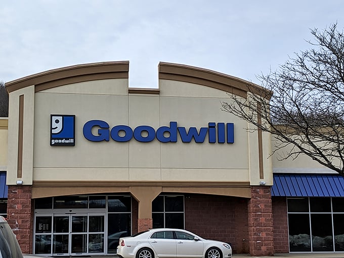 The blue Goodwill sign beckons like a lighthouse for bargain hunters. This unassuming exterior houses treasures that would make any thrift enthusiast's heart skip a beat.