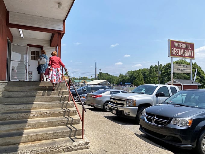 Hungry patrons climb the steps to Watermill Restaurant, where Cave City's best-kept culinary secret awaits behind those unassuming doors.