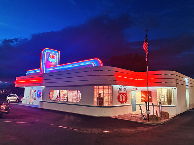 The 66 Diner glows like a neon-trimmed time machine against the Albuquerque night sky, beckoning hungry travelers with its classic Streamline Moderne architecture.