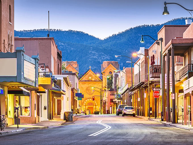 Twilight transforms Santa Fe's streets into a painting come to life, where adobe buildings glow like embers against the mountain backdrop.