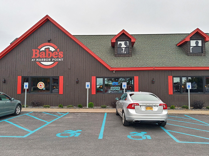 The gray building with bold red trim stands like a beacon of culinary promise against the blue Utica sky. Harbor Point's hidden gem awaits.