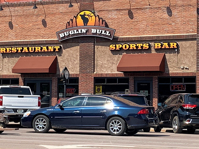 The brick facade of Buglin' Bull welcomes hungry travelers with its iconic elk silhouette sign. Those hanging flower baskets aren't just pretty&mdash;they're your first hint that this place cares about details.