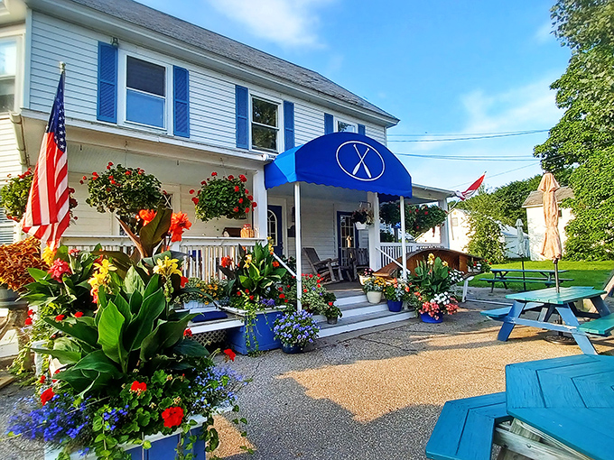 The Blue Paddle's charming exterior welcomes you like an old friend, with vibrant flowers and that signature blue awning promising culinary adventures ahead.