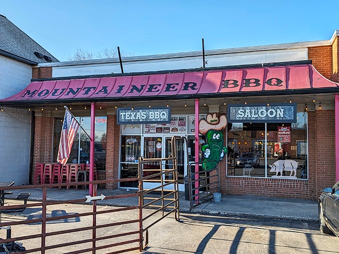 Morning light hits the Mountaineer BBQ storefront like it's auditioning for a food documentary, complete with patriotic flair and that cheeky pickle mascot.