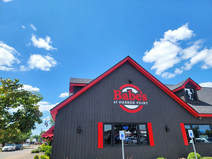 The gray building with bold red trim stands like a beacon of culinary promise against the blue Utica sky. Harbor Point's hidden gem awaits.