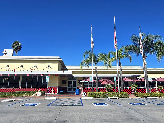 The classic Googie architecture of Legends Classic Diner stands proudly against California's blue sky, flags waving like a retro welcome committee.