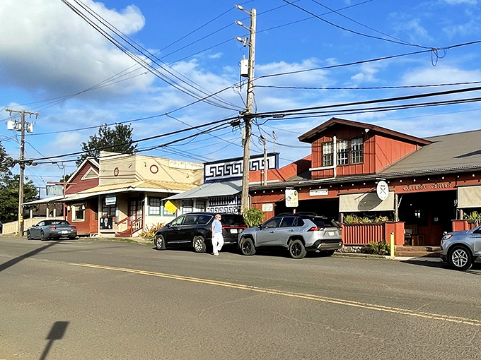 Koloa's historic storefronts stand like colorful sentinels of the past, where modern cars park alongside buildings that have witnessed a century of island stories.
