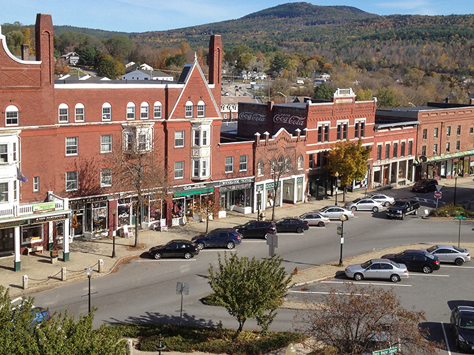 Downtown Claremont showcases its historic red brick charm against a backdrop of autumn-painted mountains. Small-town New England at its picturesque best.